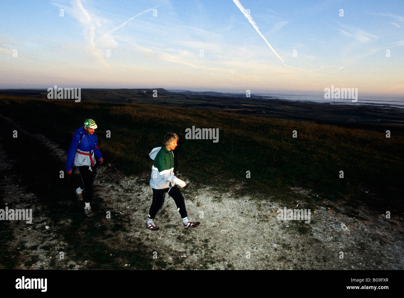 Man and woman walking along a hill top path Stock Photo - Alamy