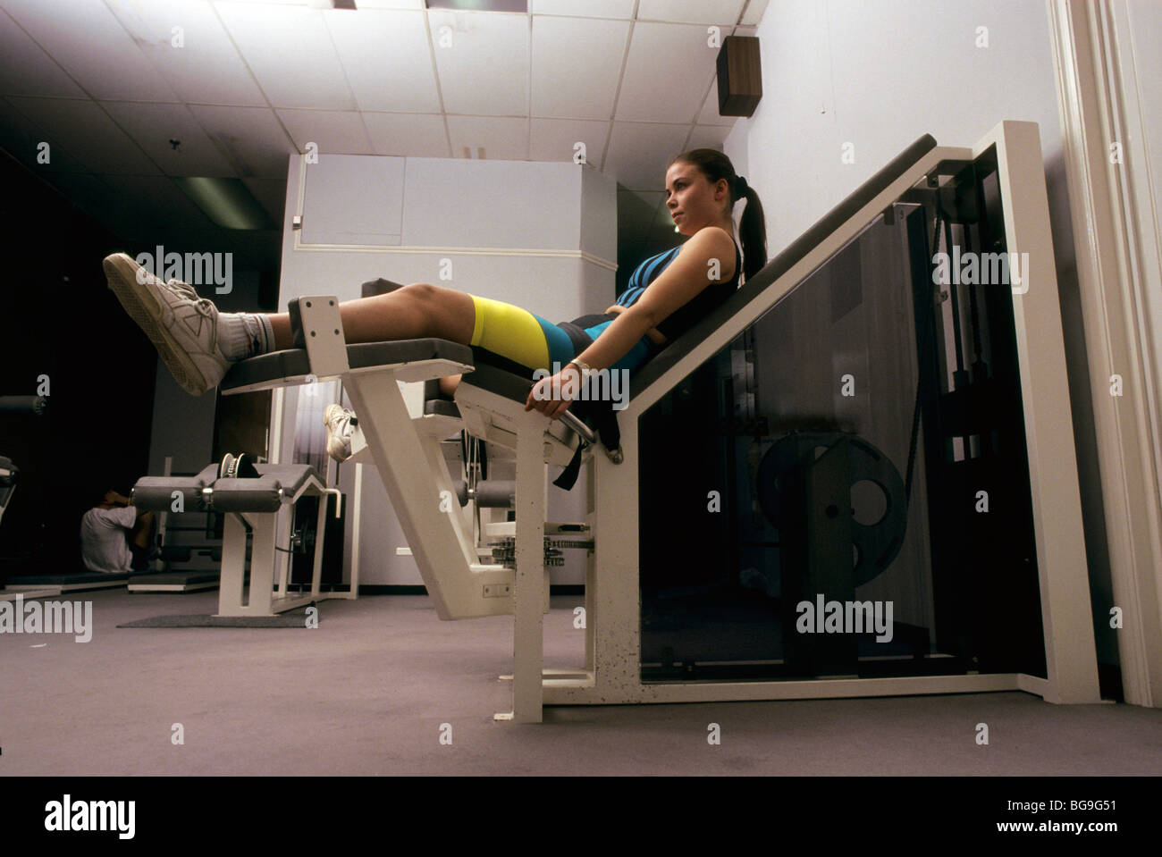 Woman working out in a gym on an abduction machine Stock Photo - Alamy