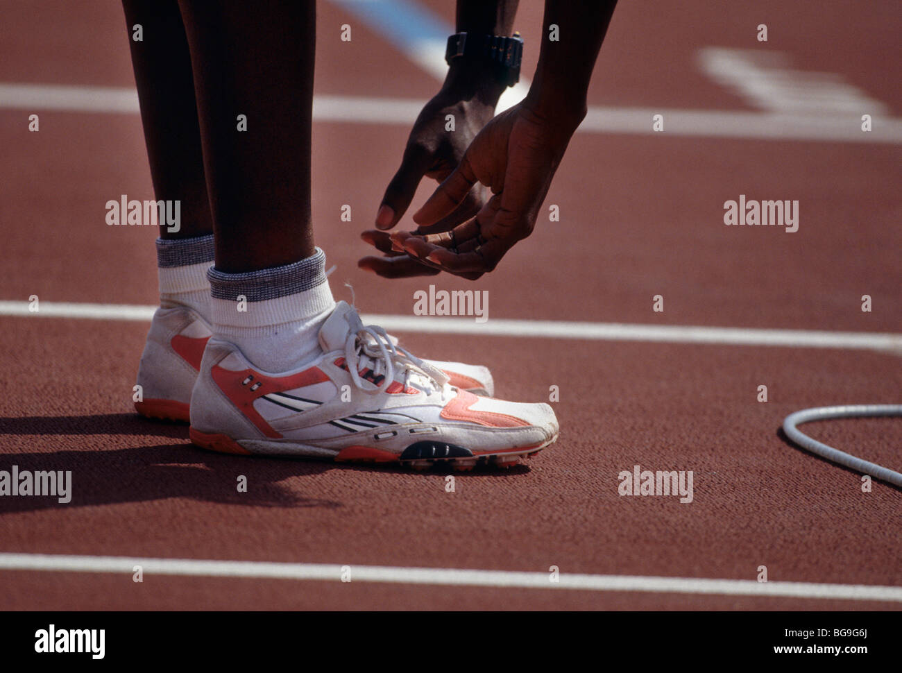 Athlete standing on a running track stretching back Stock Photo - Alamy