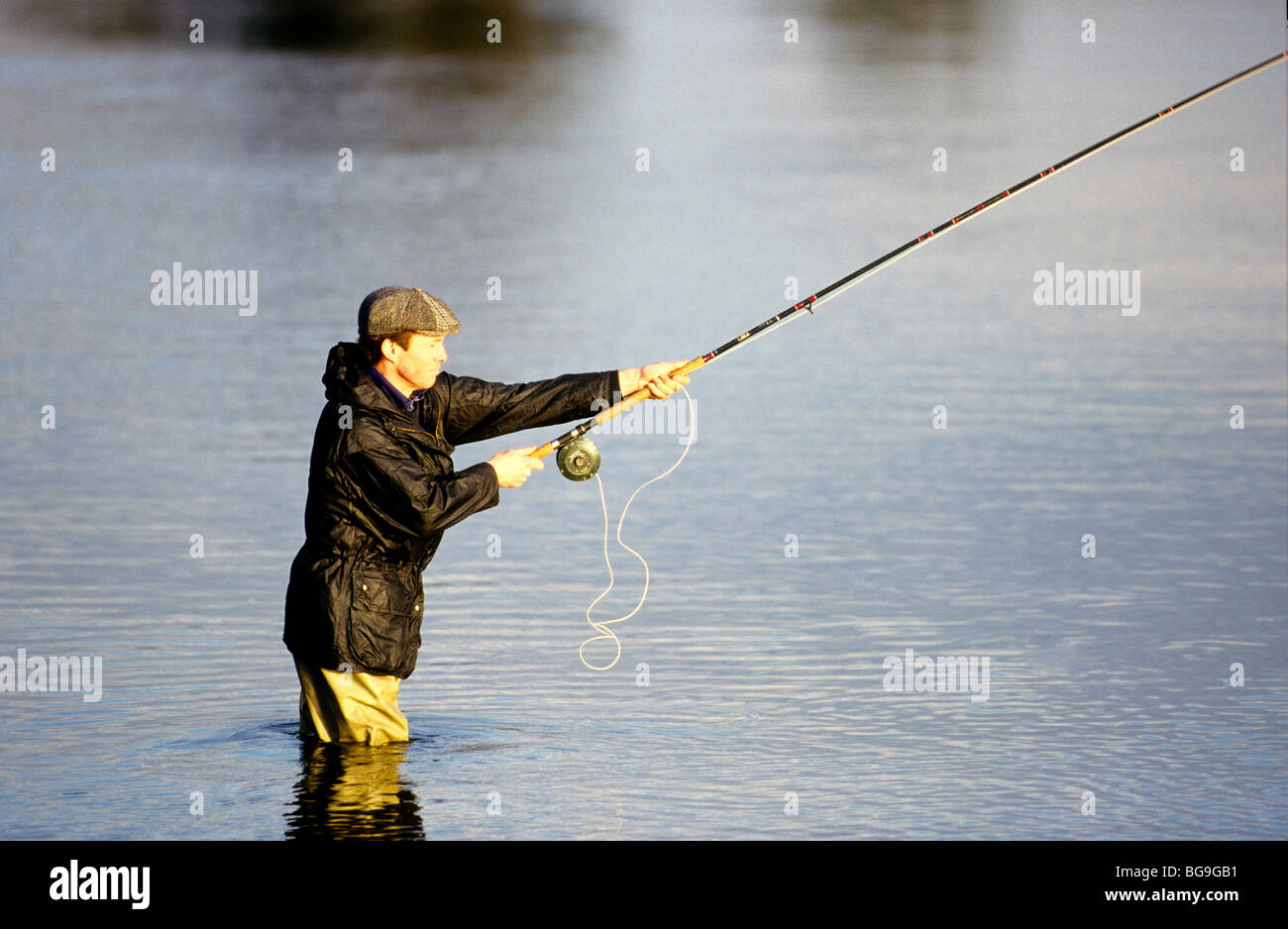 Man casting his fishing rod Stock Photo - Alamy