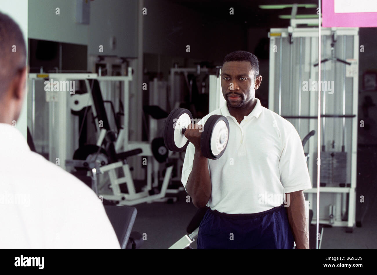 Man working with hand weights in a gym Stock Photo - Alamy