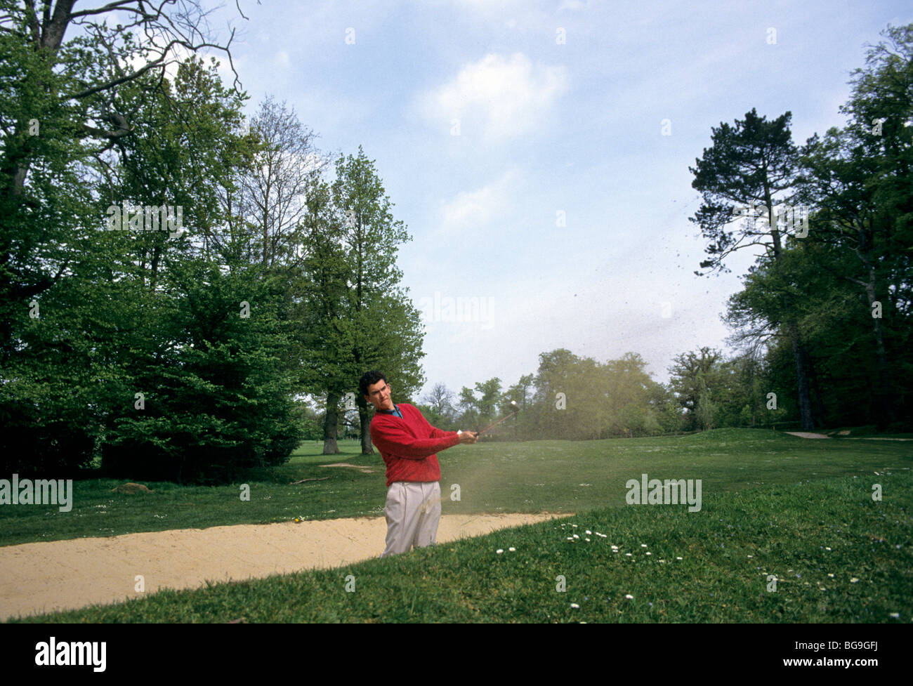 Golfer chips the ball out of the bunker Stock Photo - Alamy