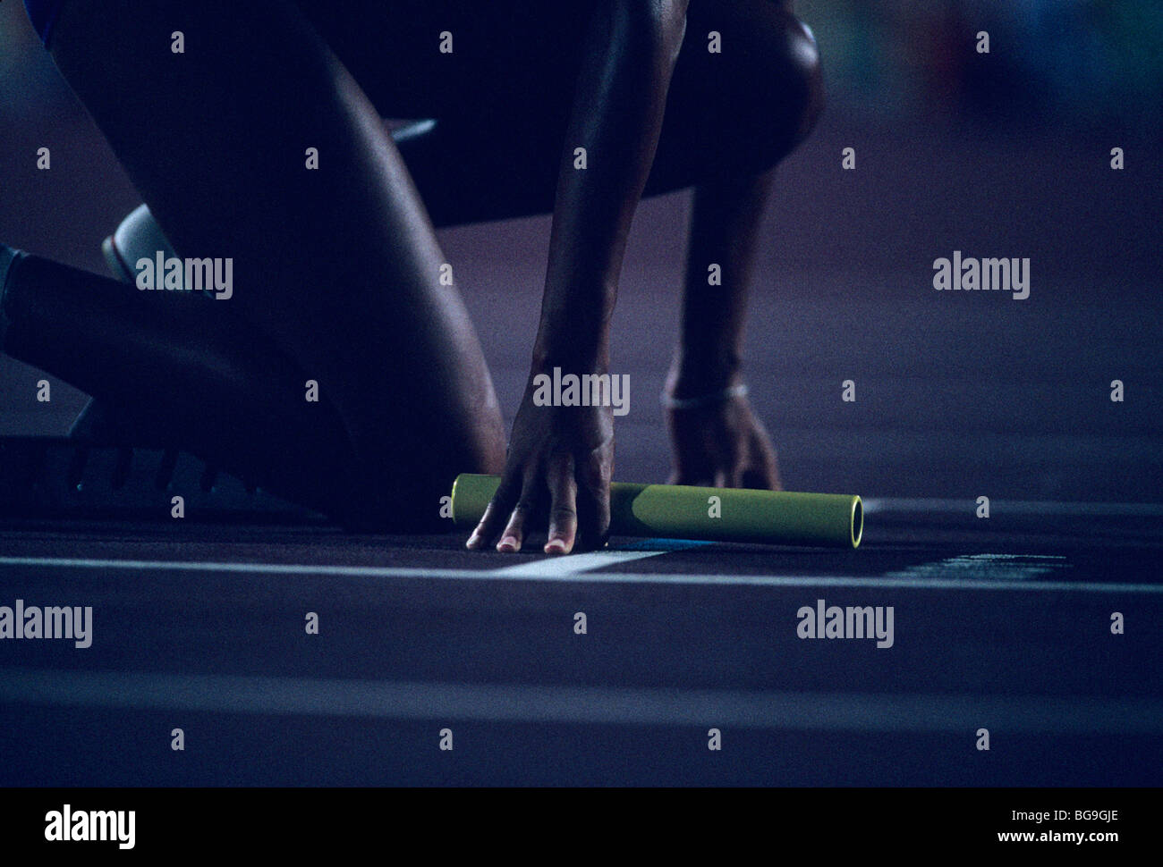 Relay sprinter in the starting block Stock Photo - Alamy