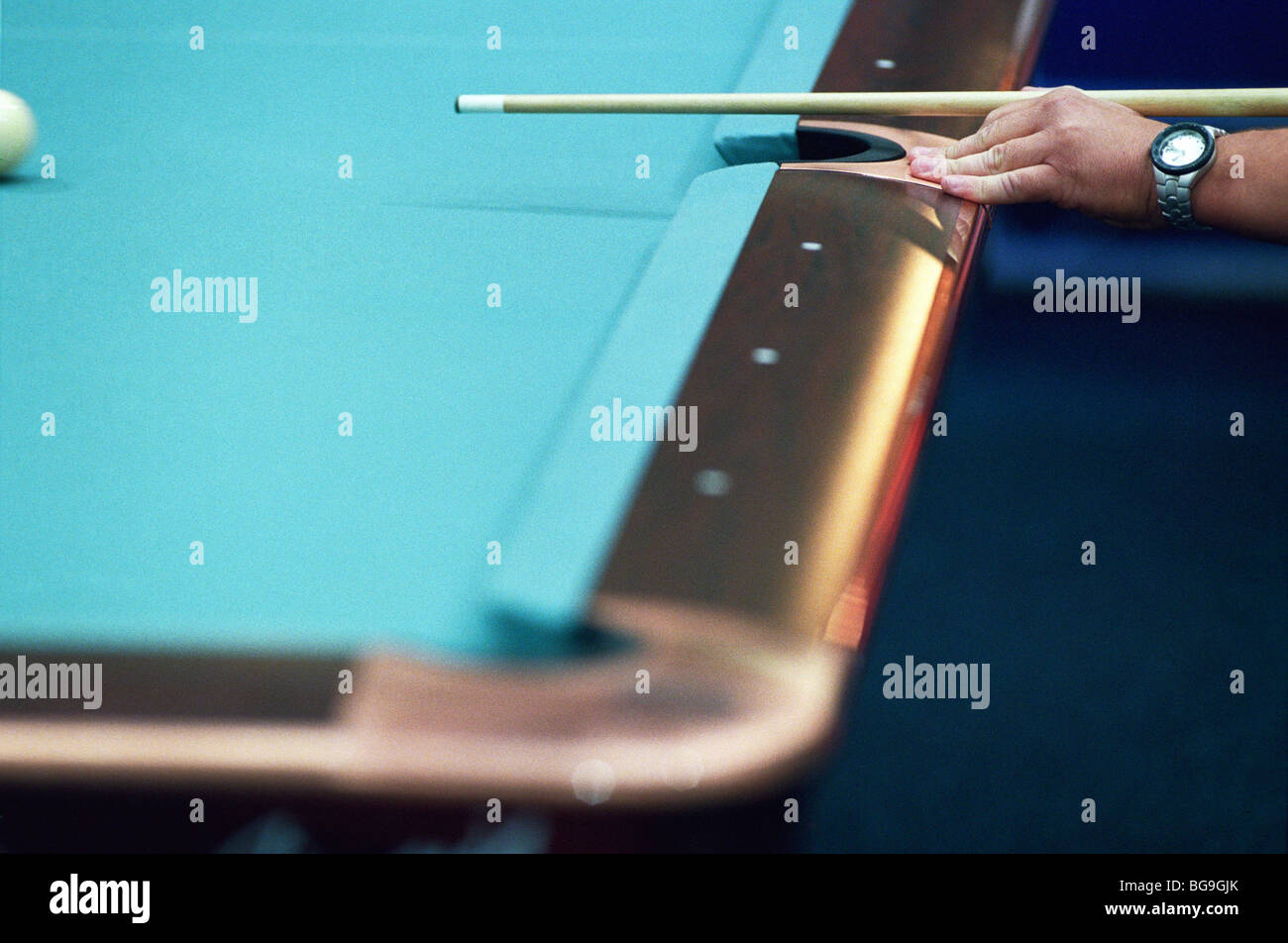 Pool player lines up his cue on the edge of a pool table Stock Photo ...