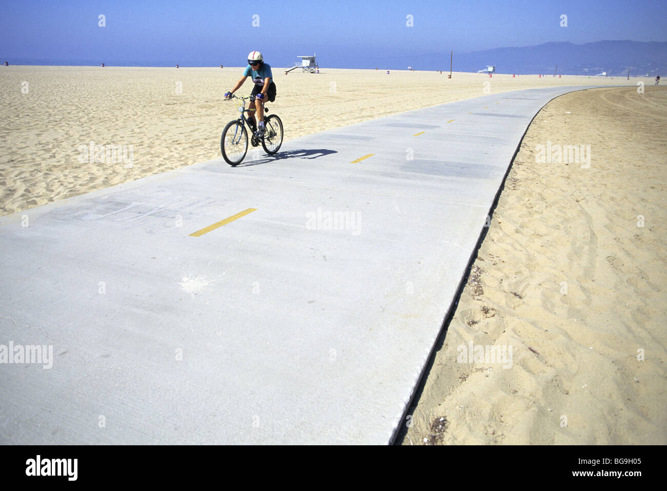 Woman cycling on a beach bike path Stock Photo - Alamy