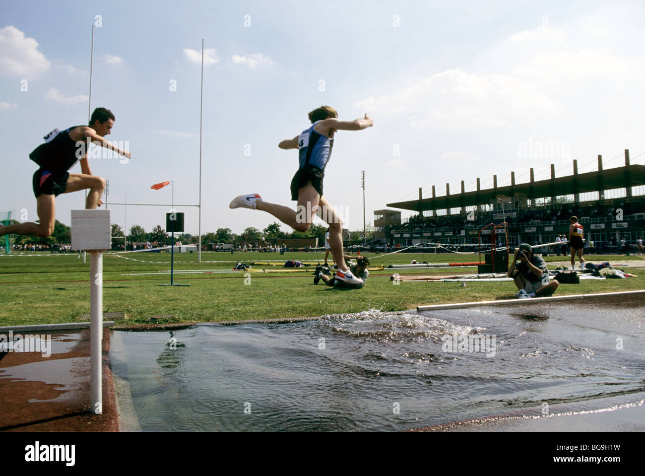 Group of male runners jumping over hurdles during a steeplechase Stock ...