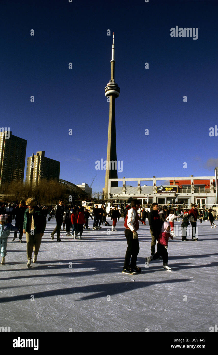 People skating on a Toronto outdoor ice rink with the CN tower in ...