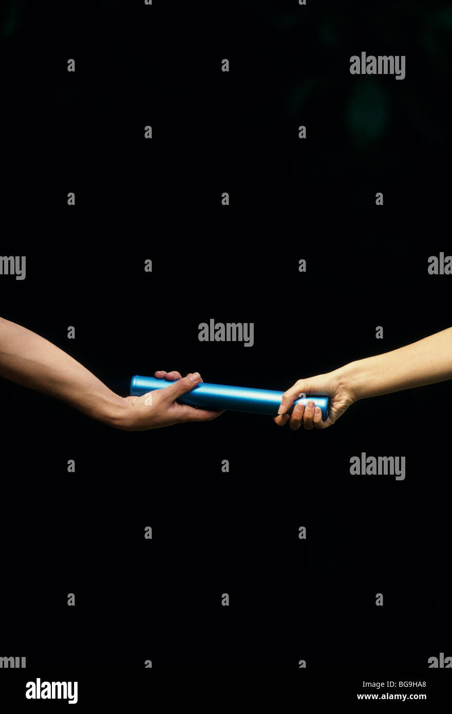 Two athletes passing a baton Stock Photo - Alamy