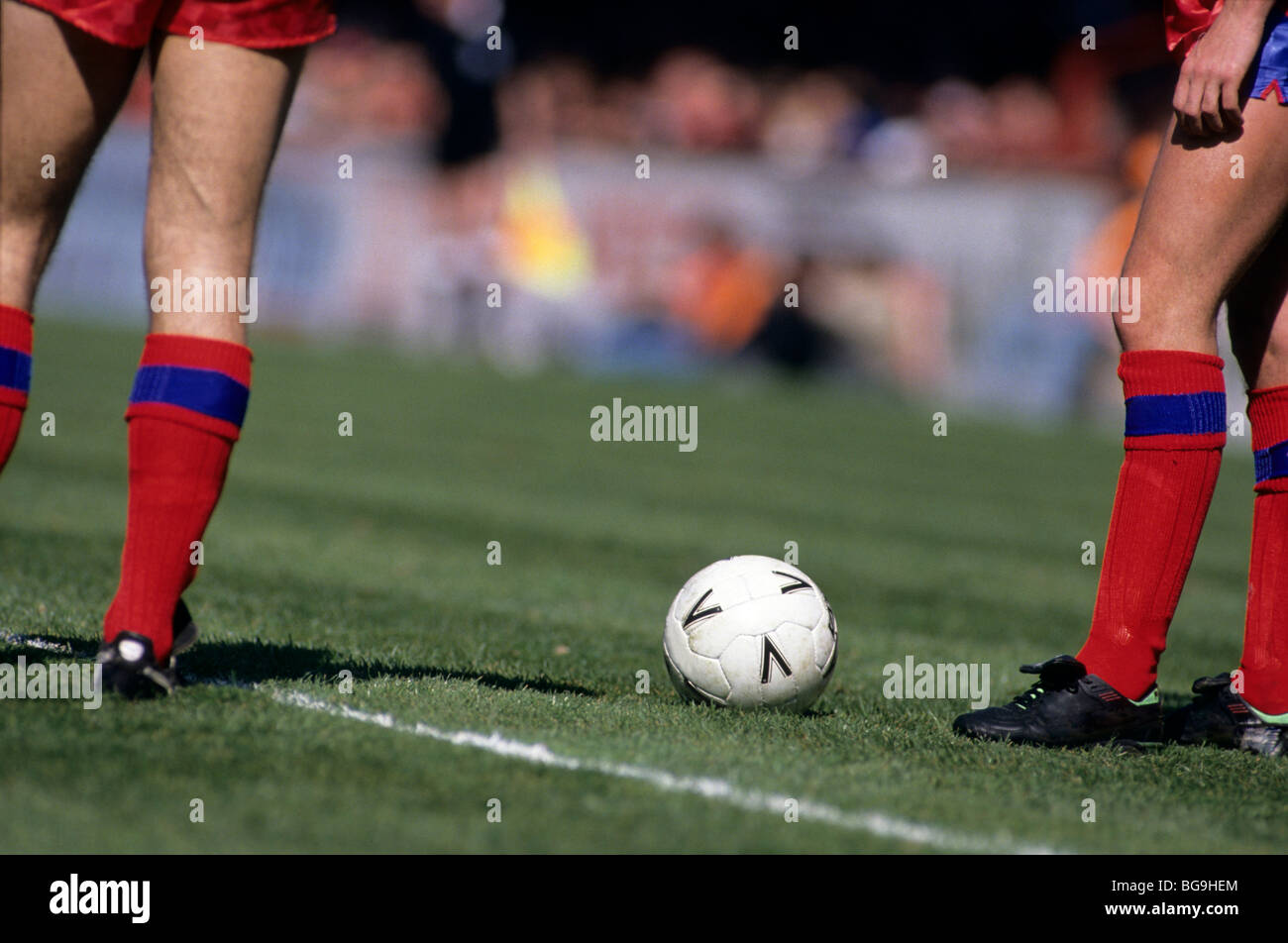 Football players legs shown with a football on a pitch Stock Photo - Alamy