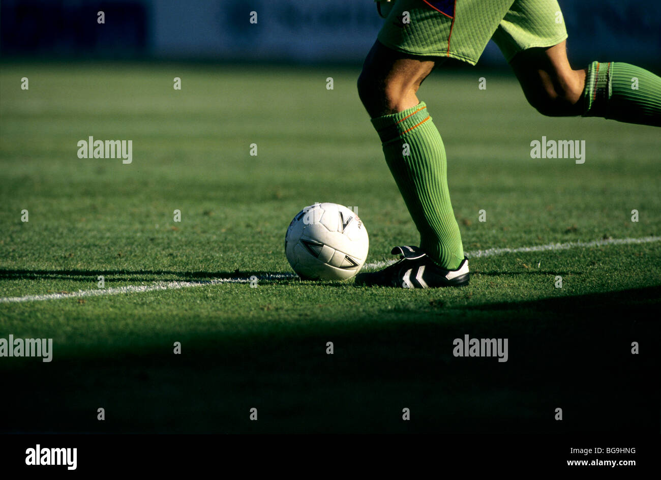 Football player kicking a ball Stock Photo - Alamy