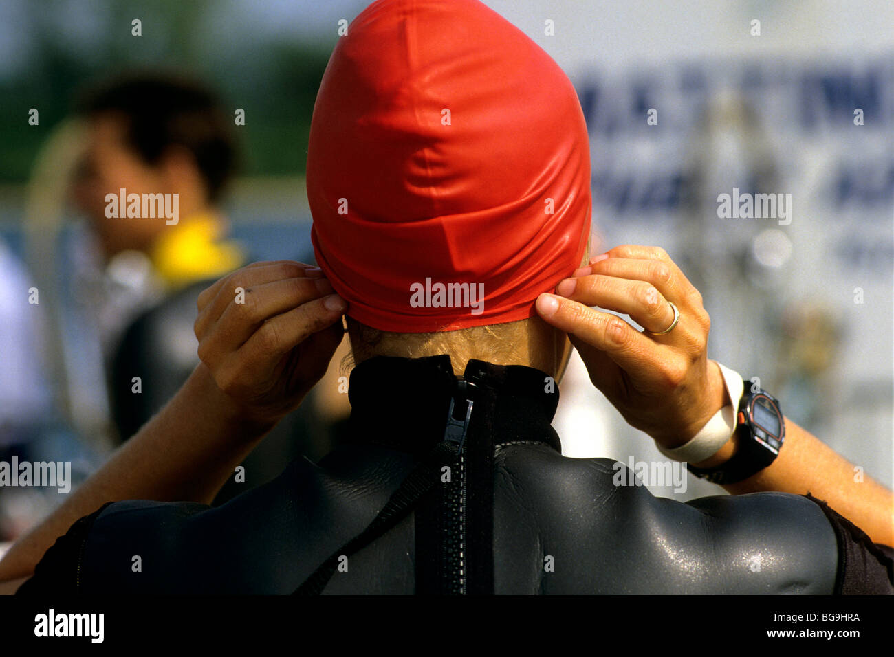 Triathlete wearing swim cap with timing watch readies for the start of ...