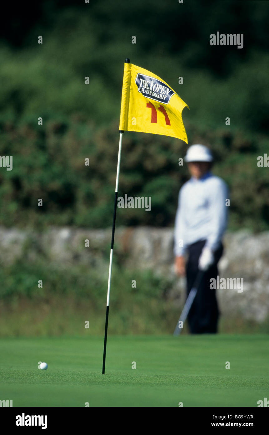 Golf flag on golf course with player in background Stock Photo - Alamy