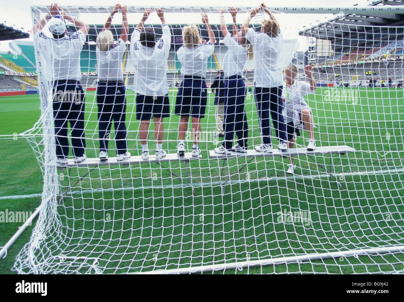 Ball boys and girls setting up a football goal net Stock Photo - Alamy