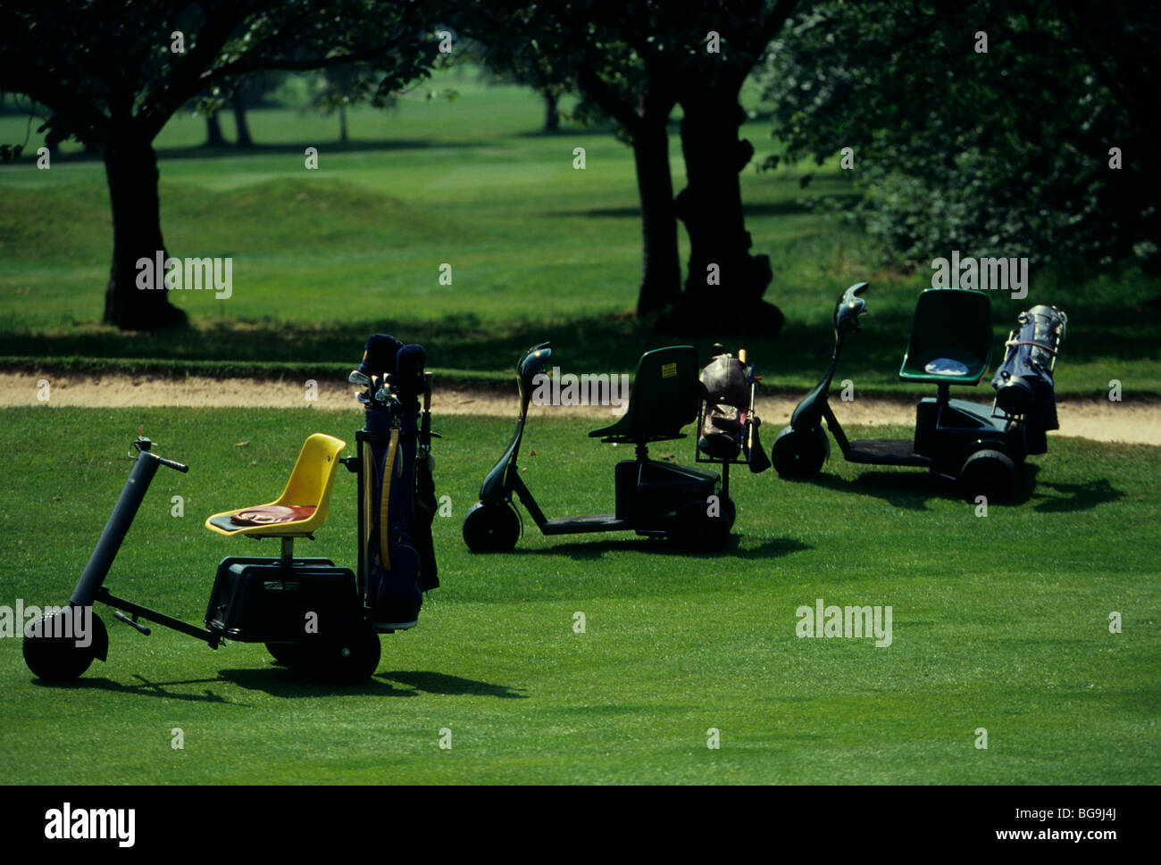 Three motorised golf carts with golf bags by a sand bunker Stock Photo ...