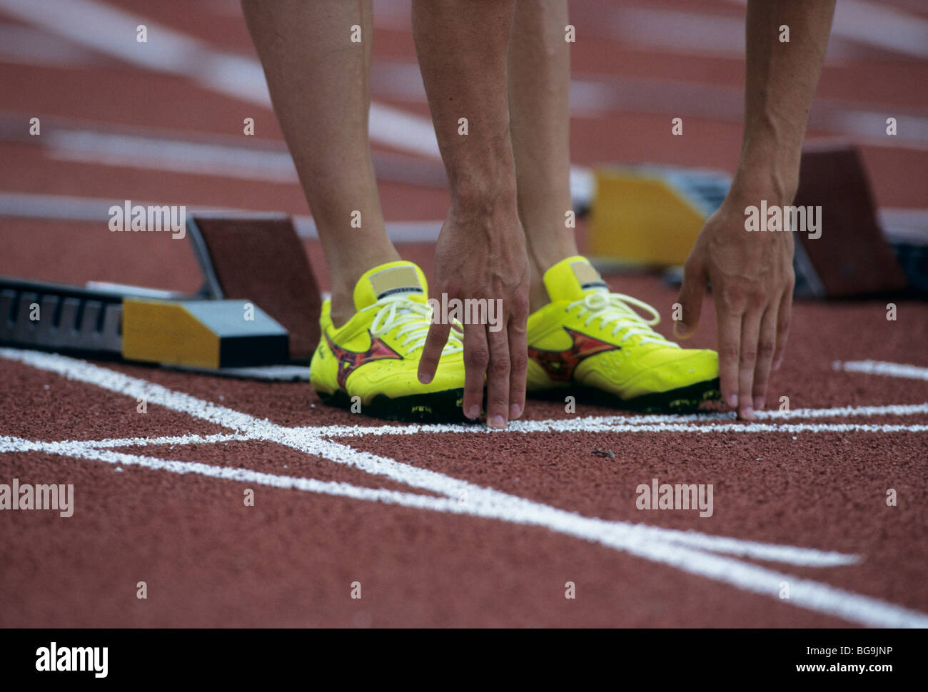 Sprinter touching starting line with finger tips Stock Photo - Alamy