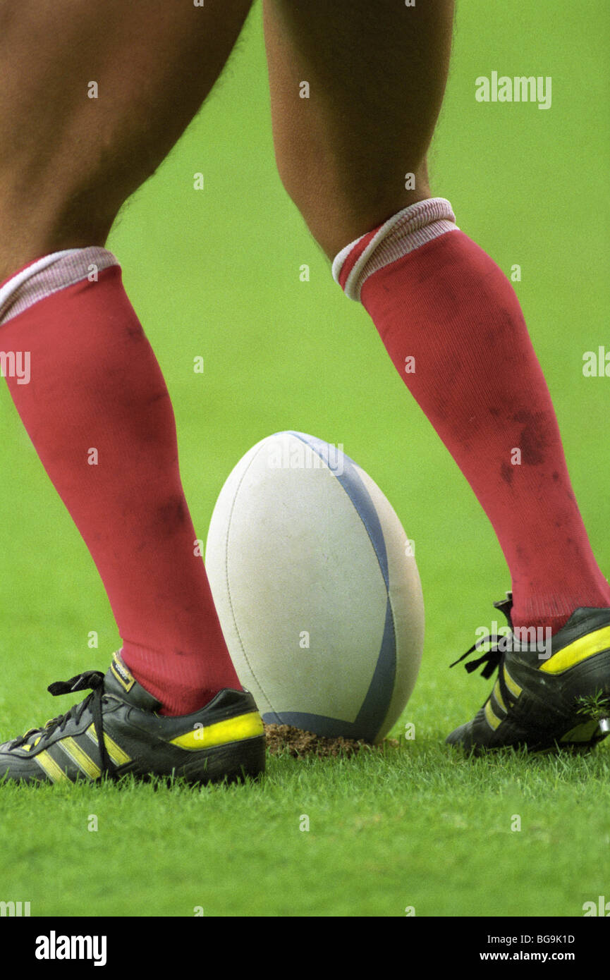 Rugby player standing by a rugby ball Stock Photo - Alamy