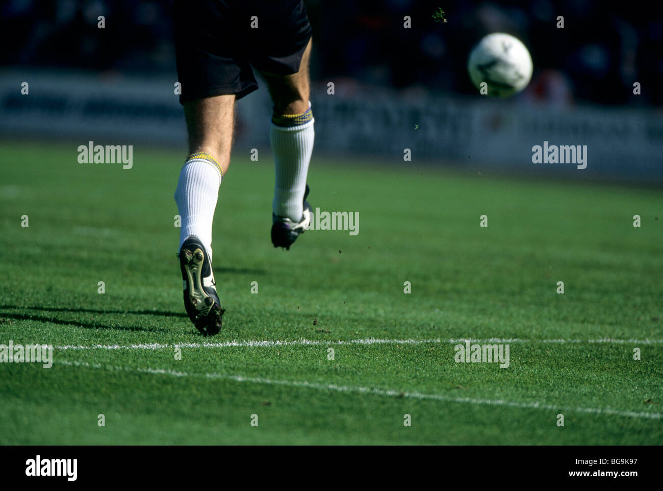 Football player kicking a ball Stock Photo - Alamy