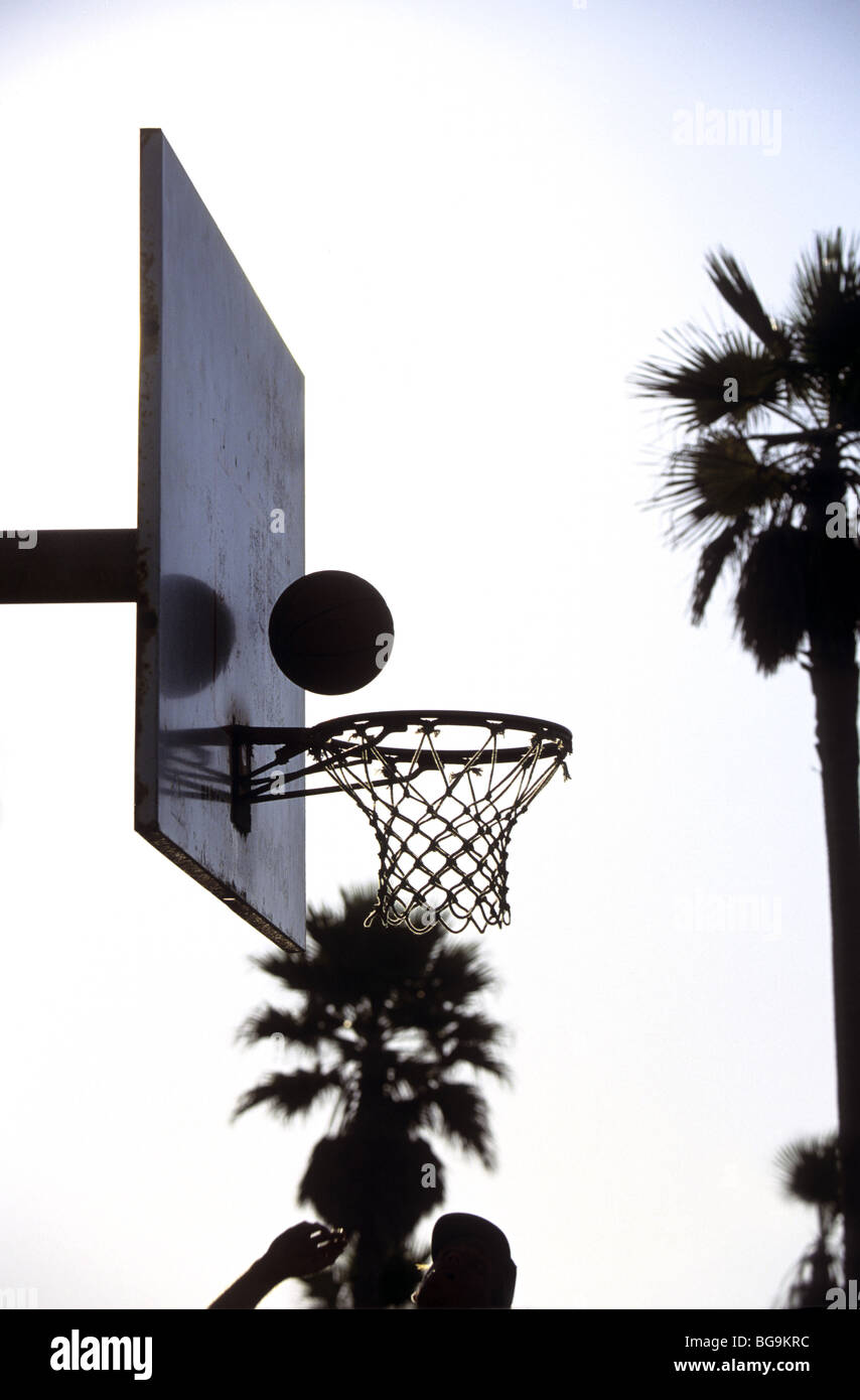 Basketball player shooting ball into net outdoors Stock Photo - Alamy