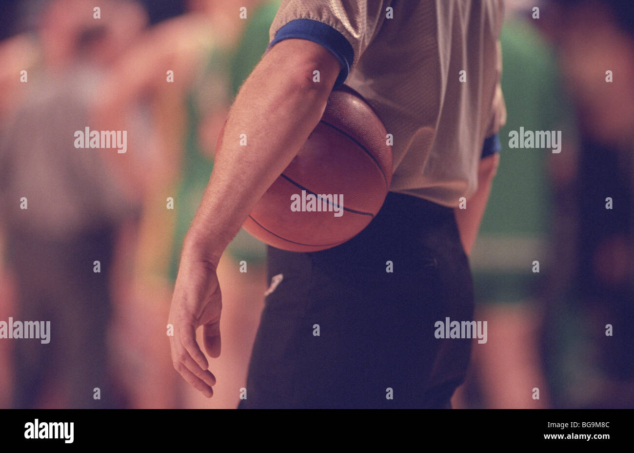 Referee holding basketball under his arm Stock Photo - Alamy