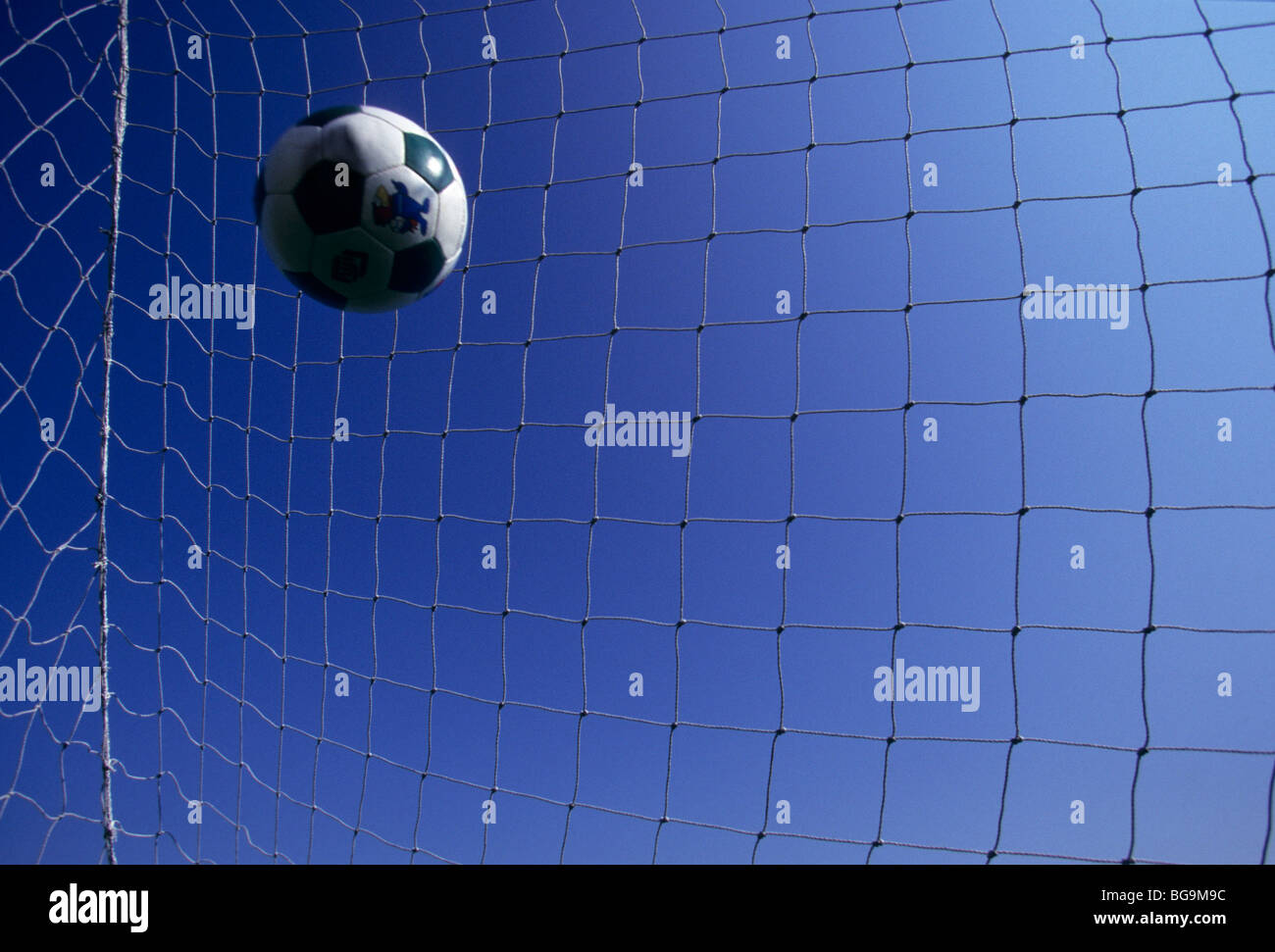 Football in a goal net against blue sky Stock Photo - Alamy