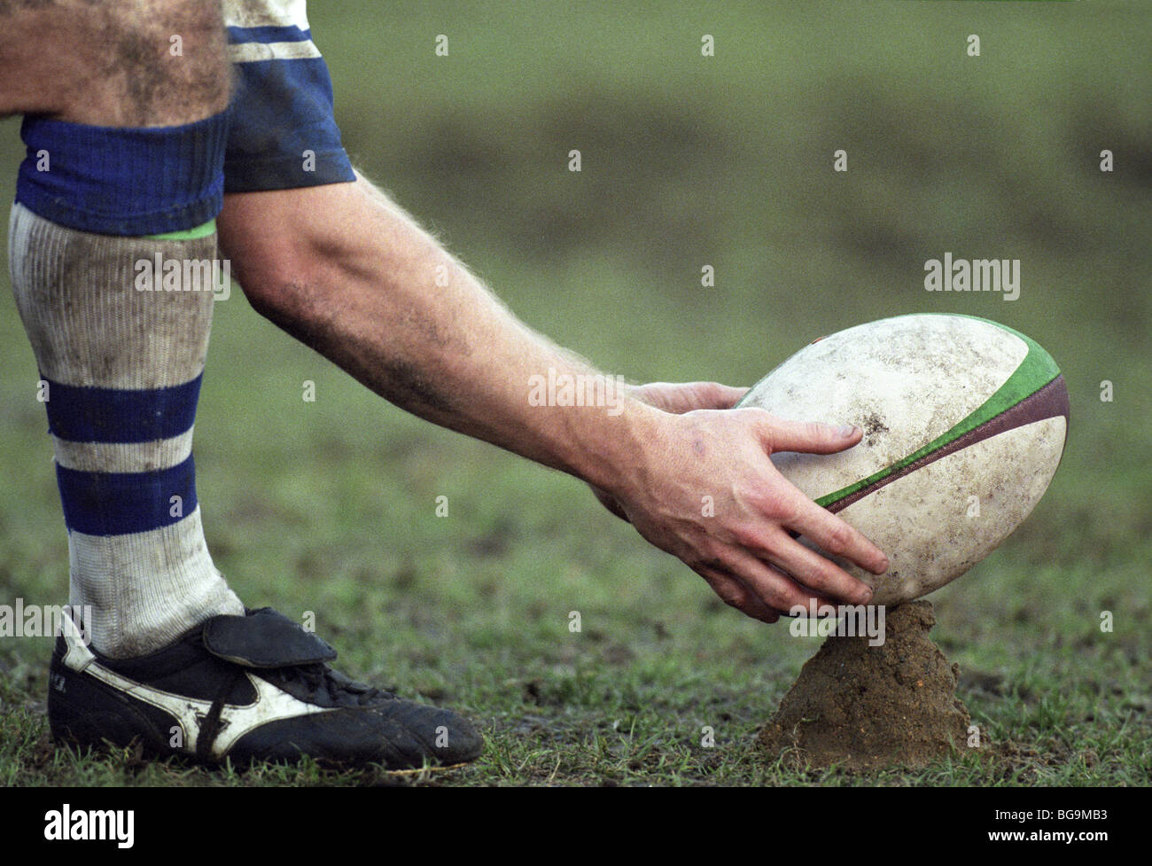 Rugby player placing rugby ball on soil tee Stock Photo - Alamy