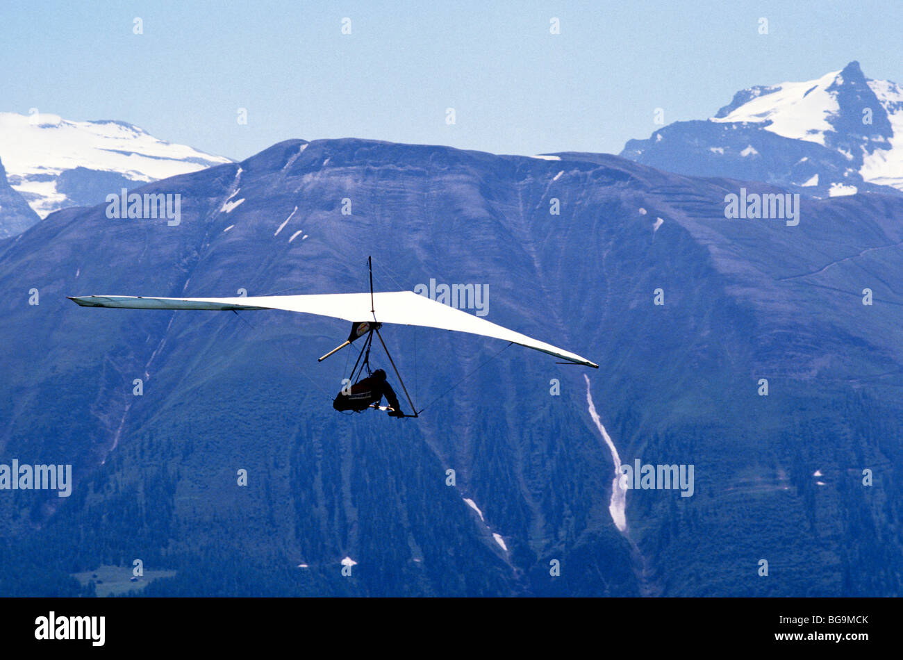 Hang gliding over snow capped mountains Stock Photo - Alamy