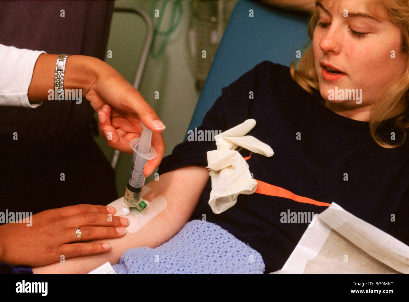 A young woman has an injection in the A&E ward of an NHS London ...