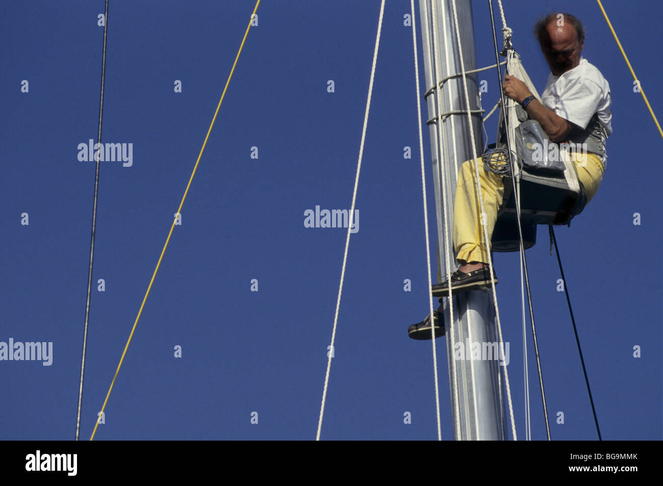 Man climbing a sailboat mast Stock Photo - Alamy