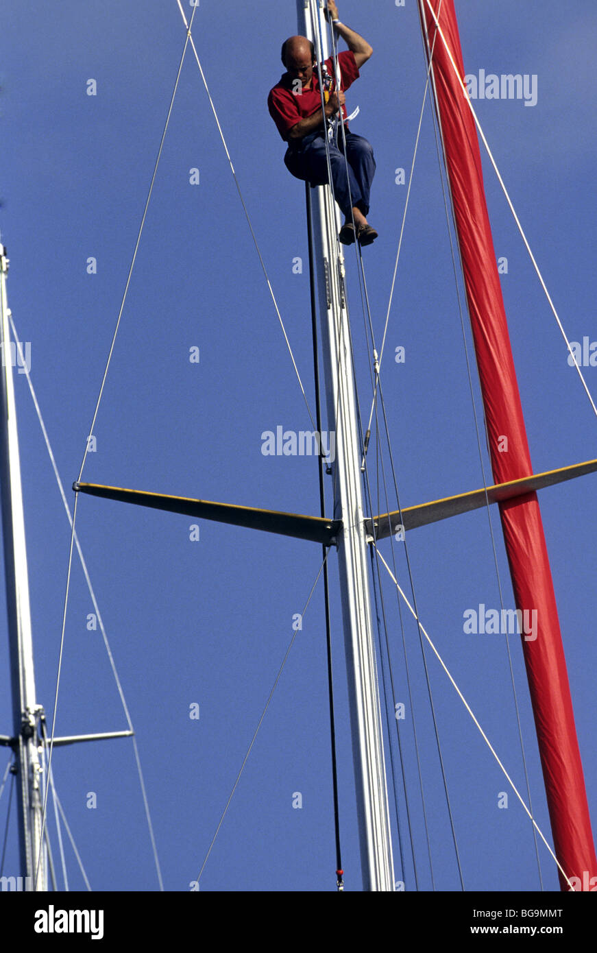 Man climbing a sailboat mast Stock Photo - Alamy