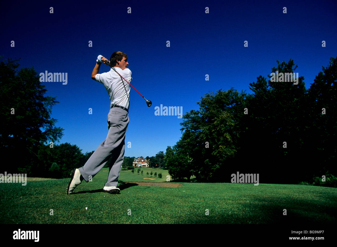 Golfer tees off on a golf course Stock Photo - Alamy