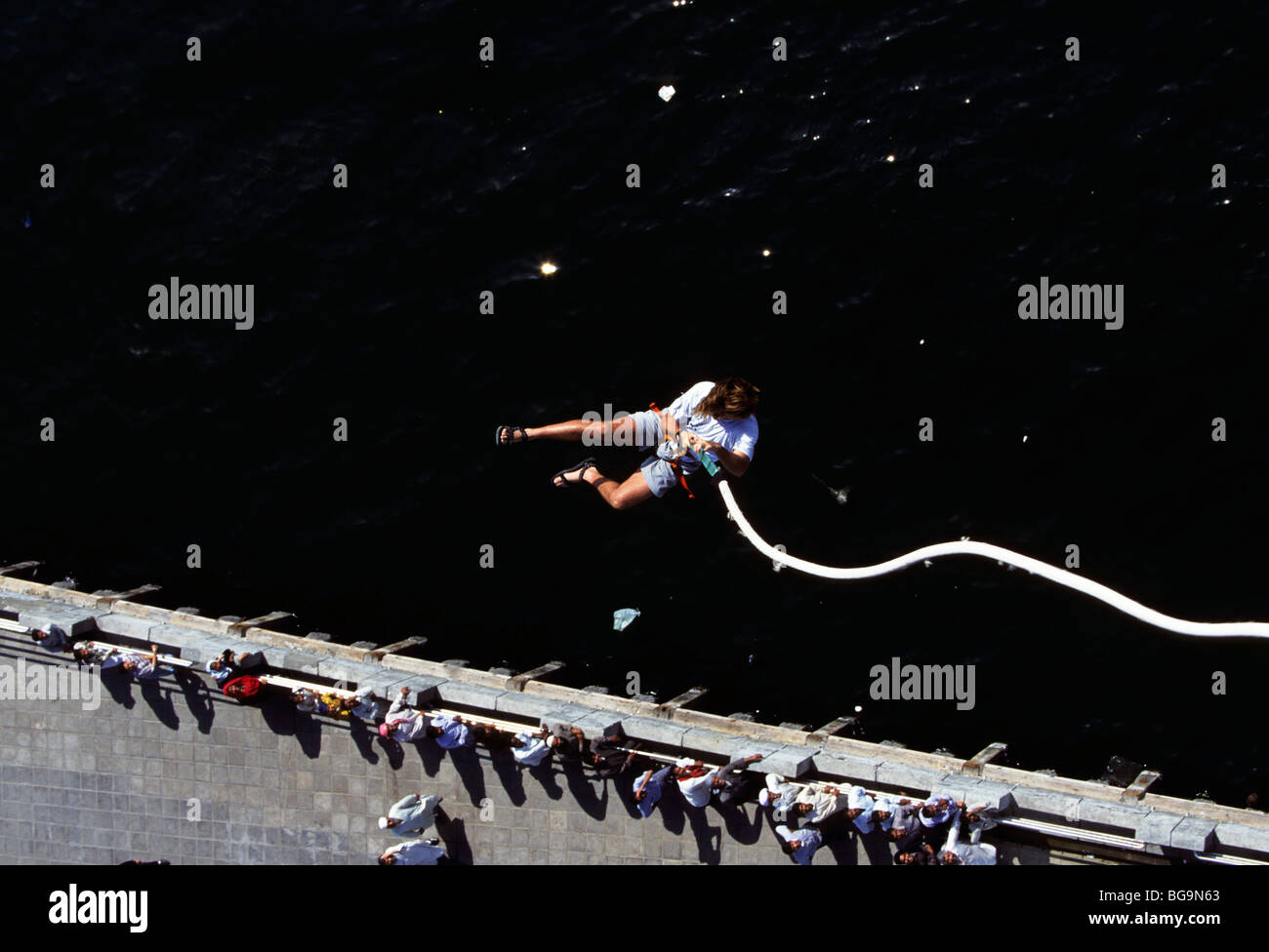 Man bungee jumping over a group of people Stock Photo - Alamy