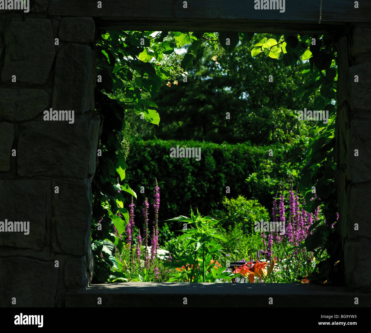 Window in stone wall looks out on a flower garden at the Toledo Botanic ...