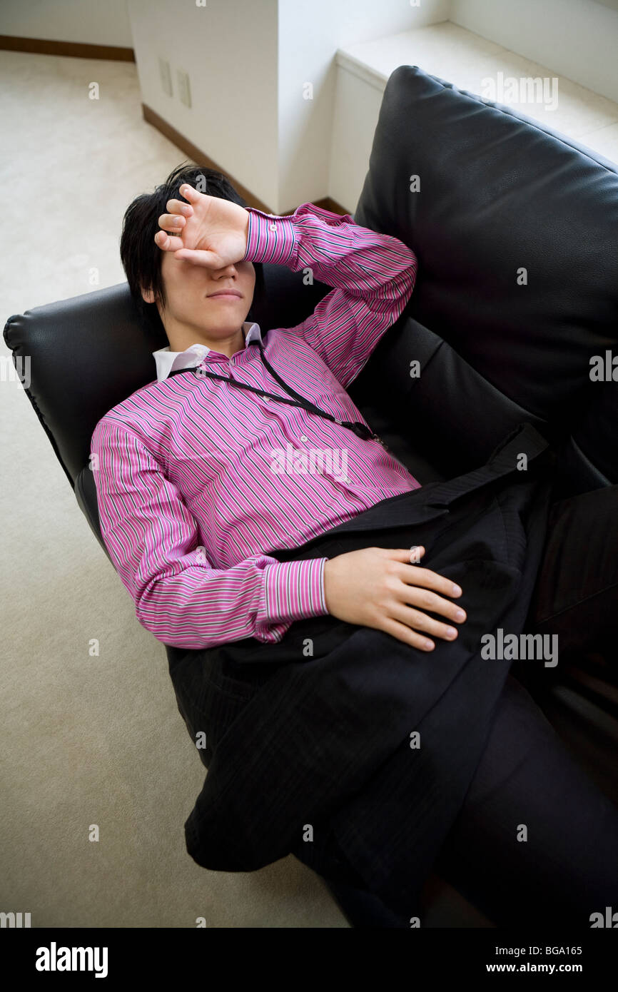 Young man resting on sofa Stock Photo - Alamy