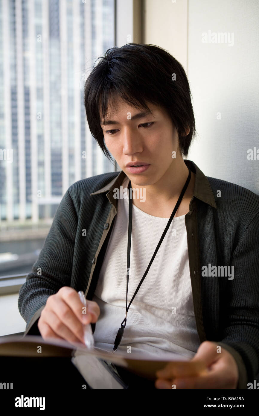 Young man checking documents Stock Photo - Alamy