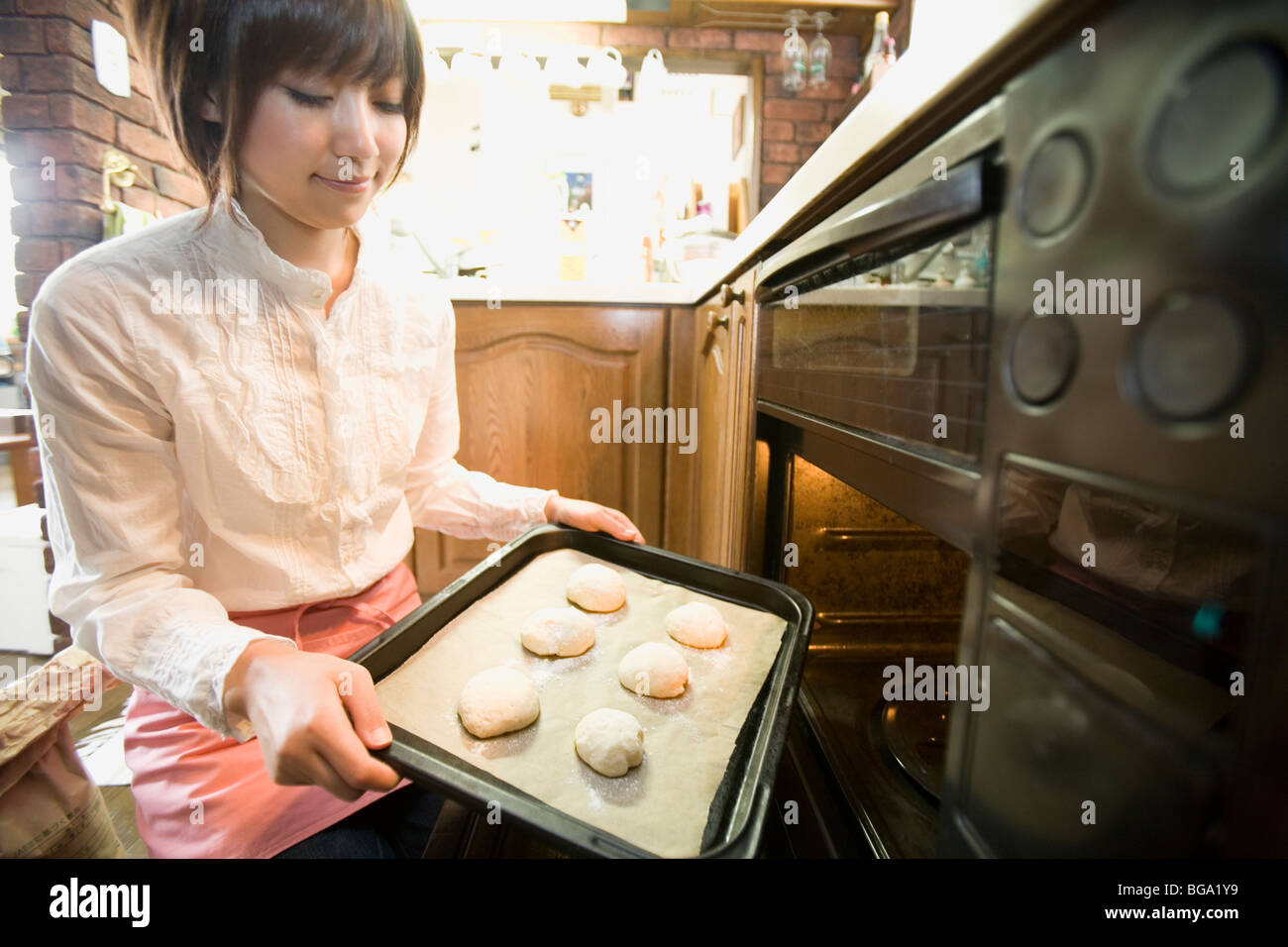 Young woman baking bread Stock Photo - Alamy