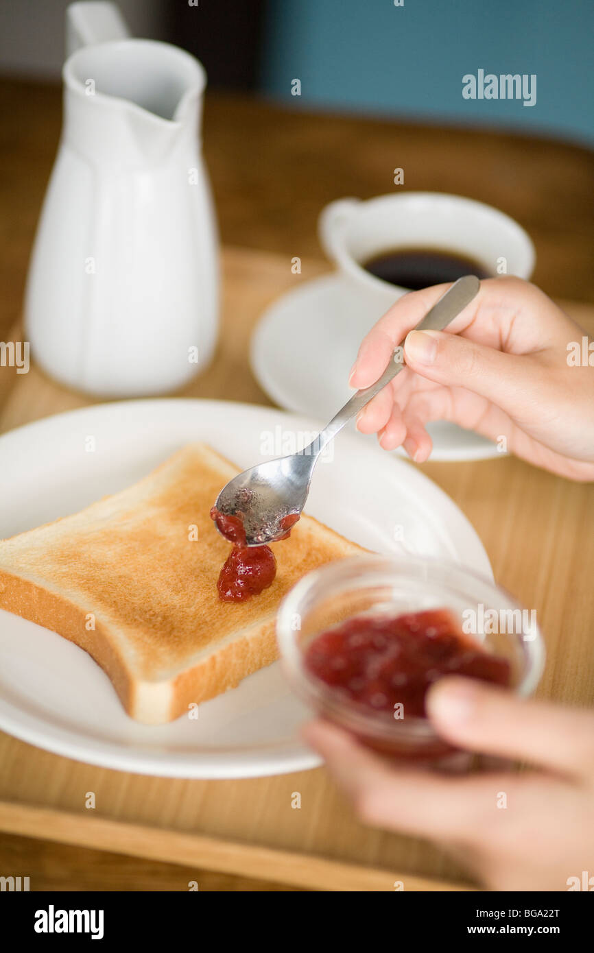 Human hand of young woman spreading jam on toast Stock Photo - Alamy