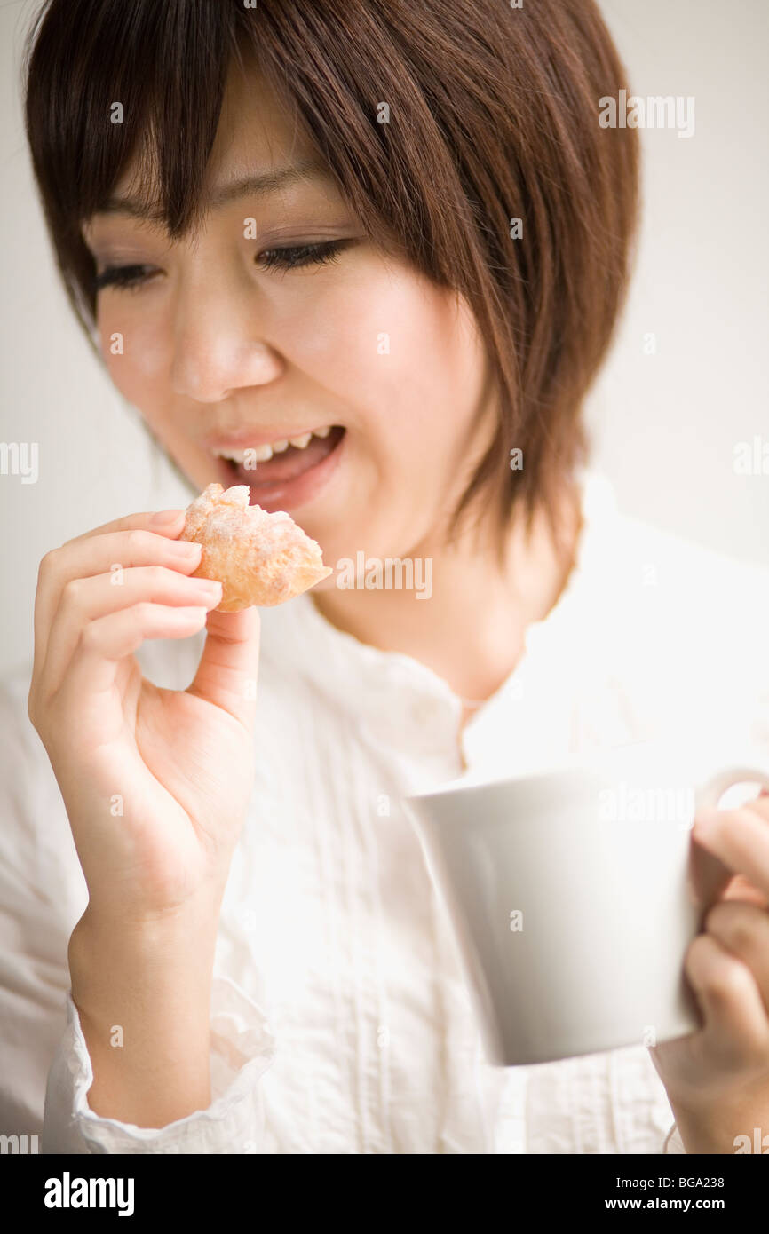 Young woman eating bread Stock Photo - Alamy