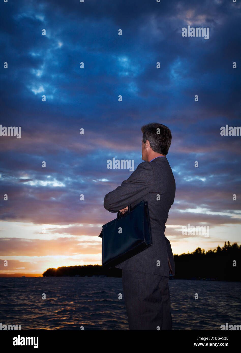 Businessman looking at the sunset Stock Photo - Alamy