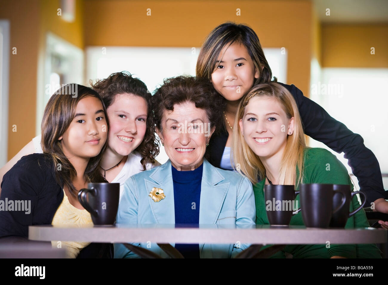 Elderly woman surrounded by young friends Stock Photo - Alamy