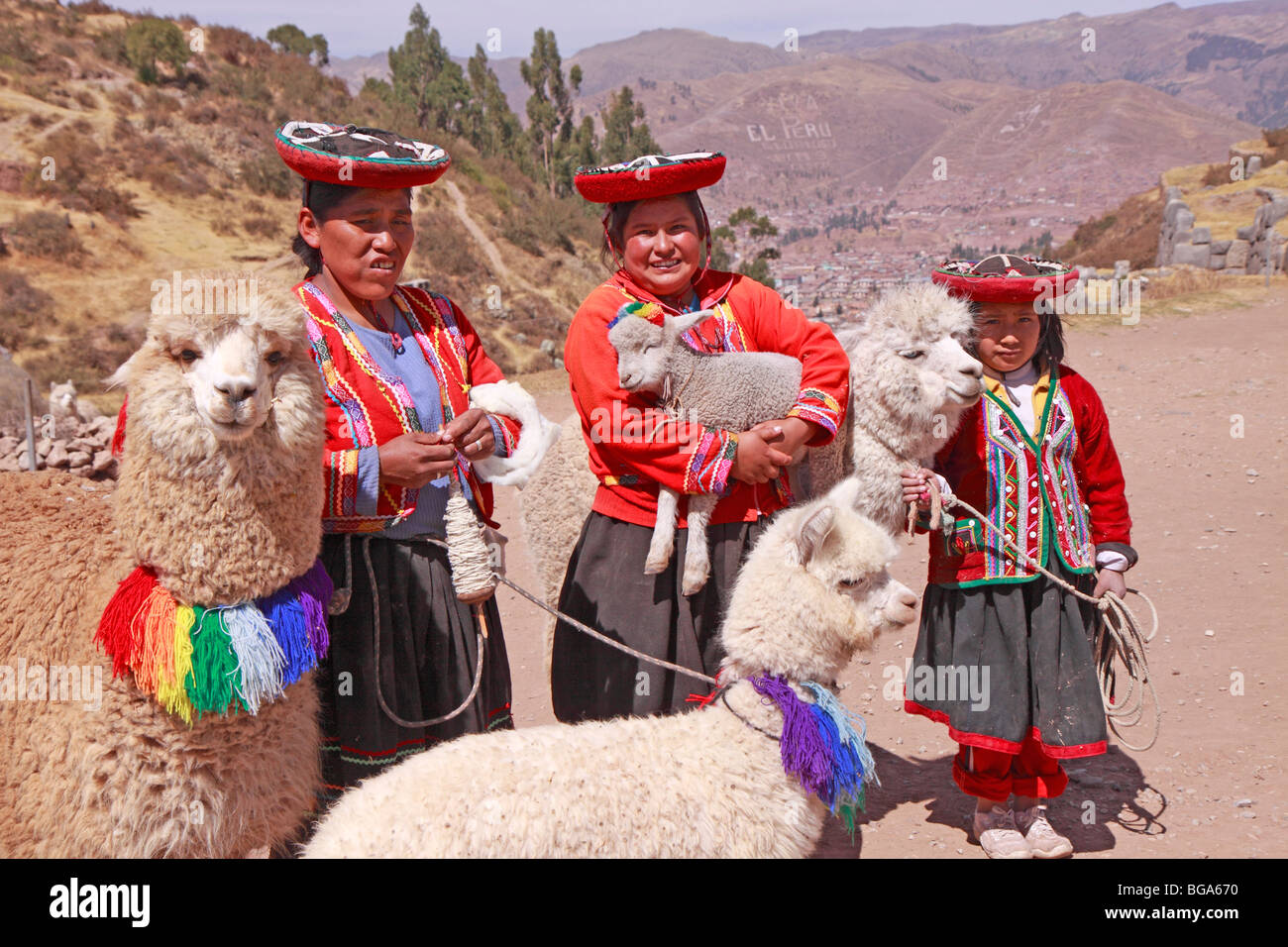 native women and girl with alpacas at the Inca ruins of Sacsayhuaman ...