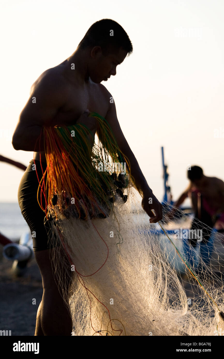 Fisherman with net on beach, Bali Stock Photo - Alamy