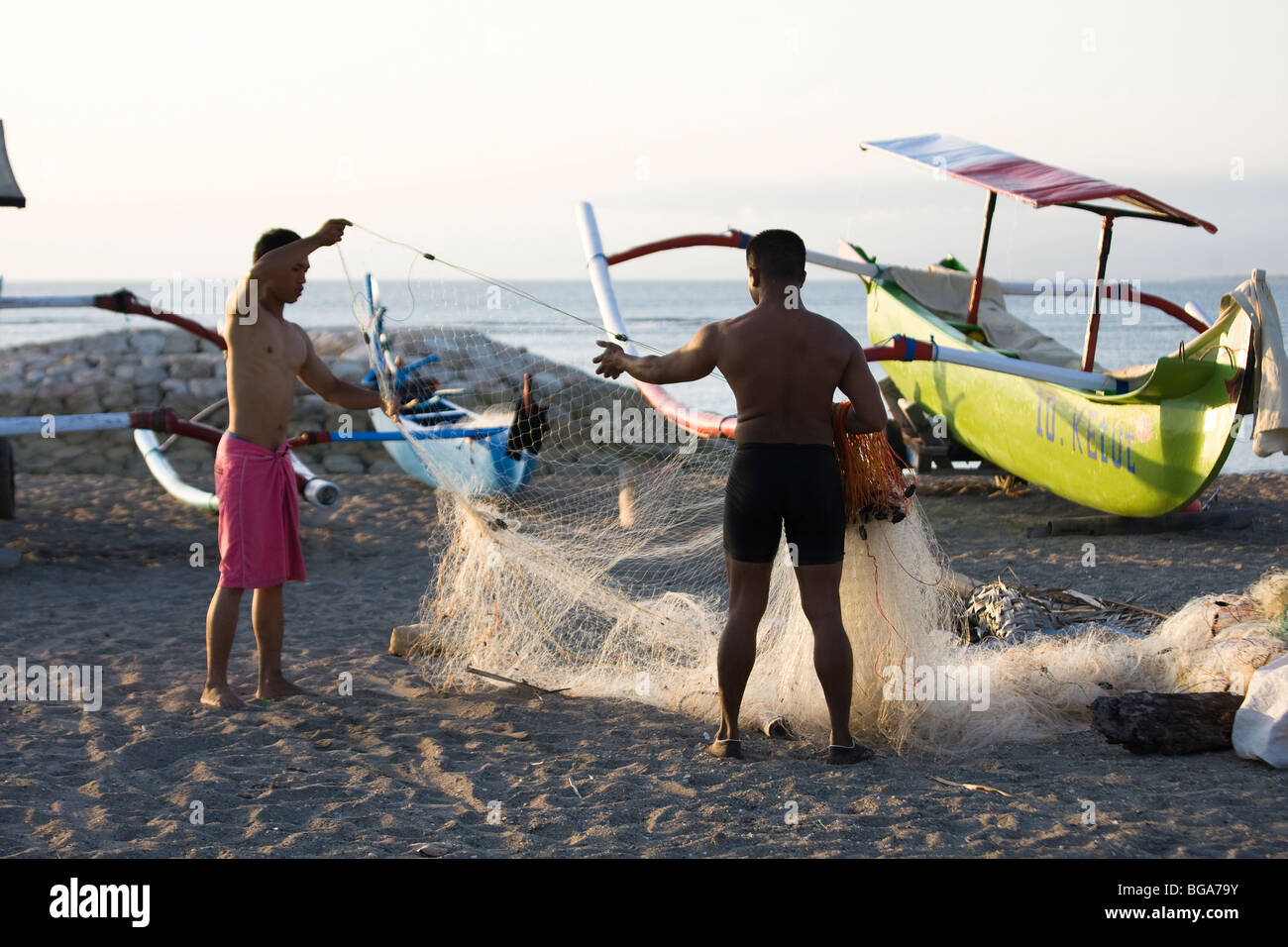 Fisherman with net on beach, Bali Stock Photo - Alamy
