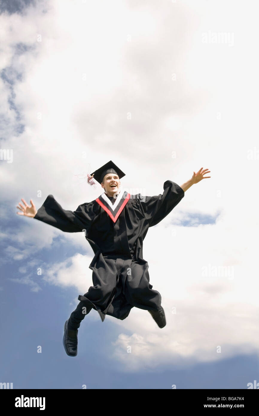 Excited graduate jumping for joy Stock Photo - Alamy