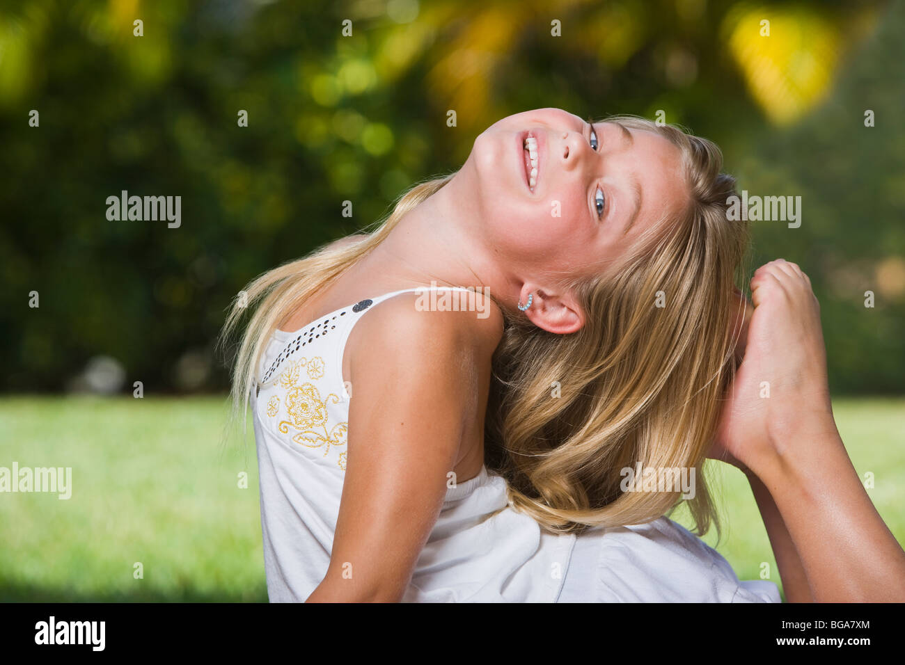 Blonde girl laying down with head up, smiling, portrait Stock Photo - Alamy