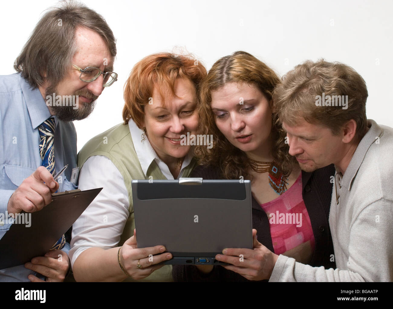 team of four business people looking with great interest at screen of ...