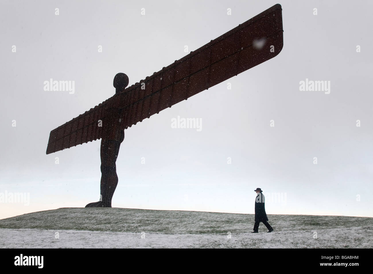 A man walks through a snowstorm below The Angel of the North, Antony ...