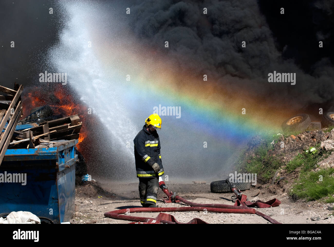 Large plumes of black smoke with fireman and rainbow from water Stock ...