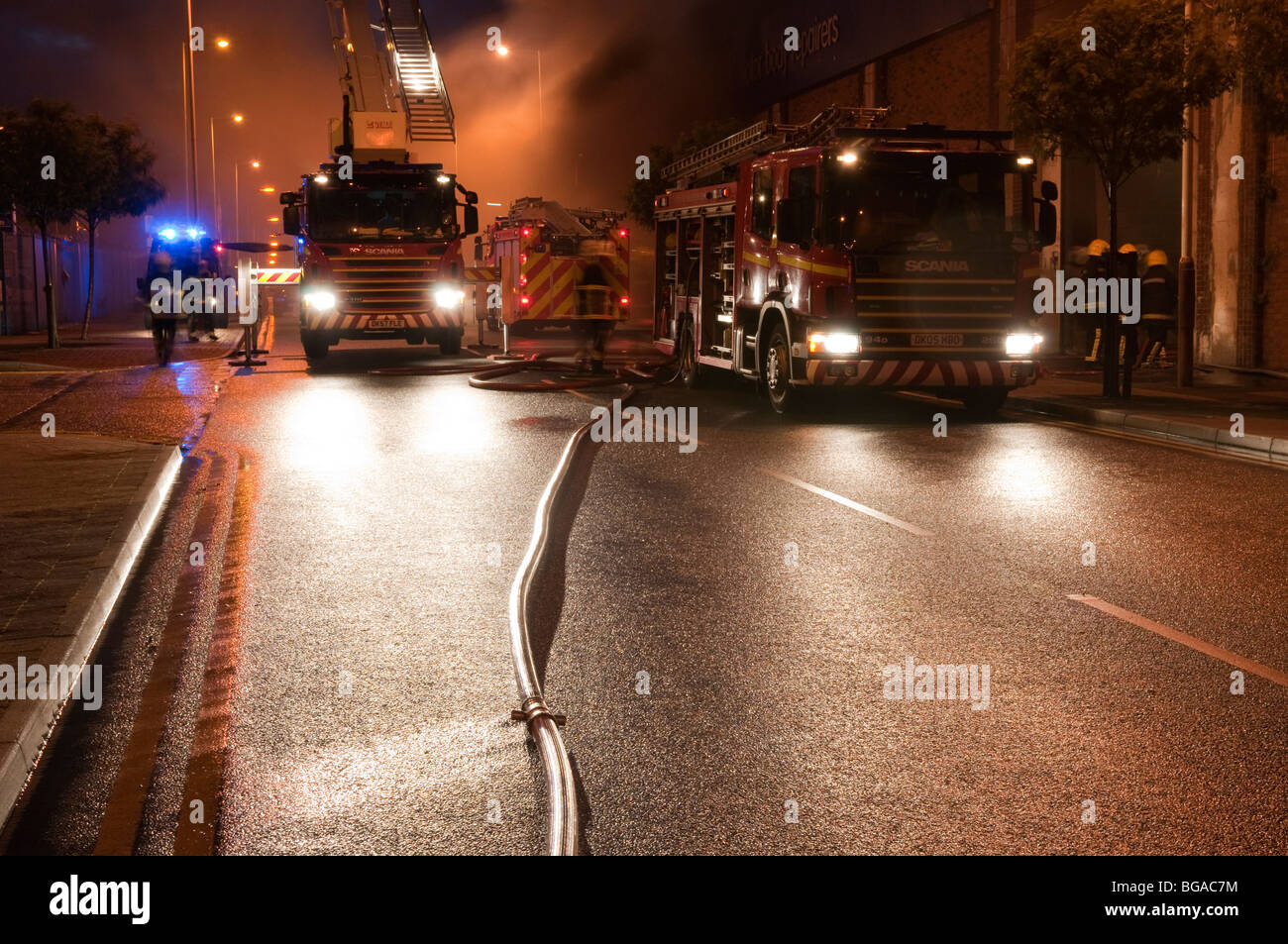 Fire Engines and hose at fire at night Stock Photo - Alamy