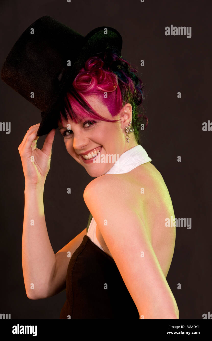A smiling young woman tips her top hat Stock Photo - Alamy