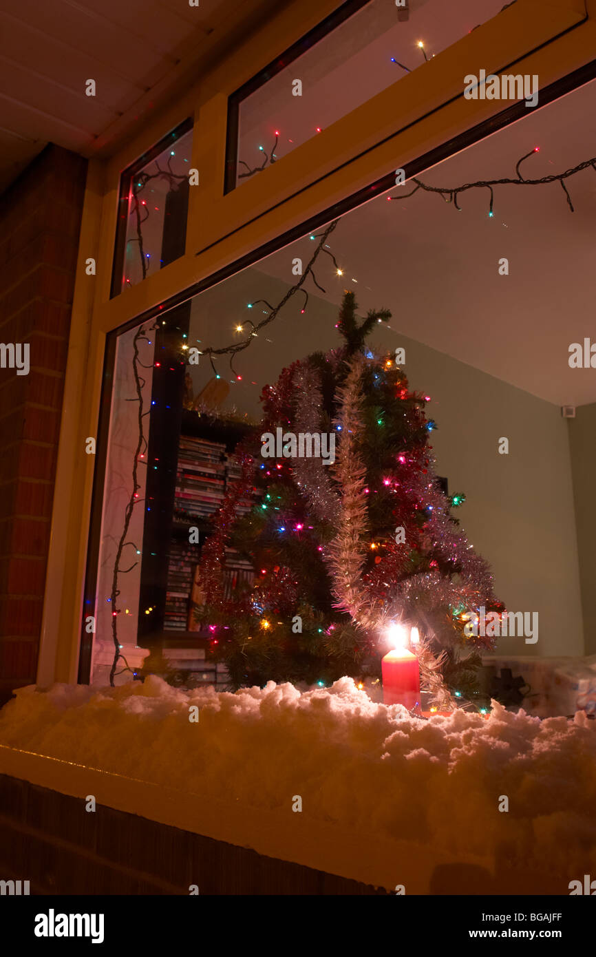 candle burning in the window of a house with christmas tree in the uk ...